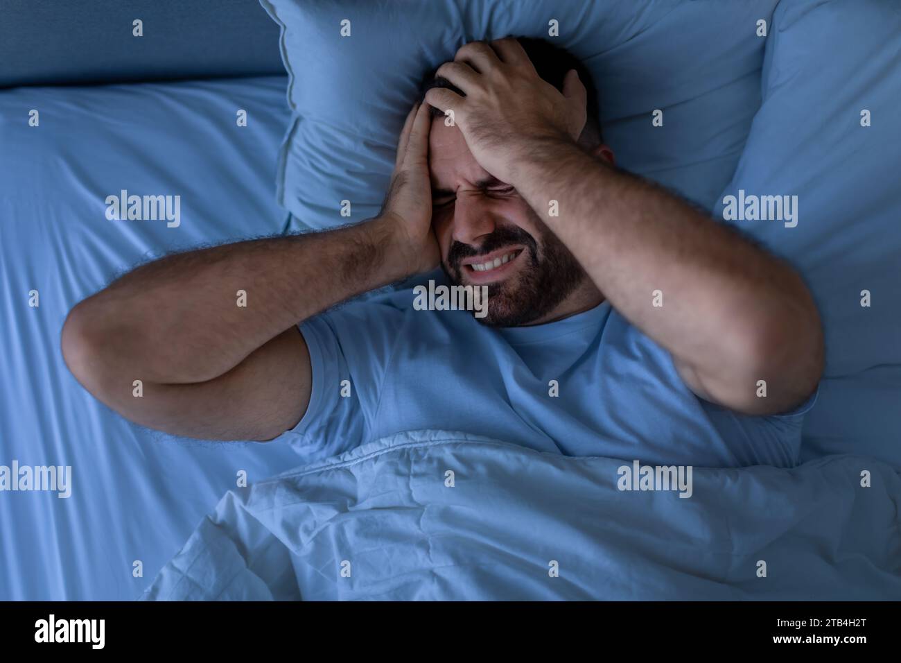 guy suffering from migraine feeling sick at night in bedroom Stock ...