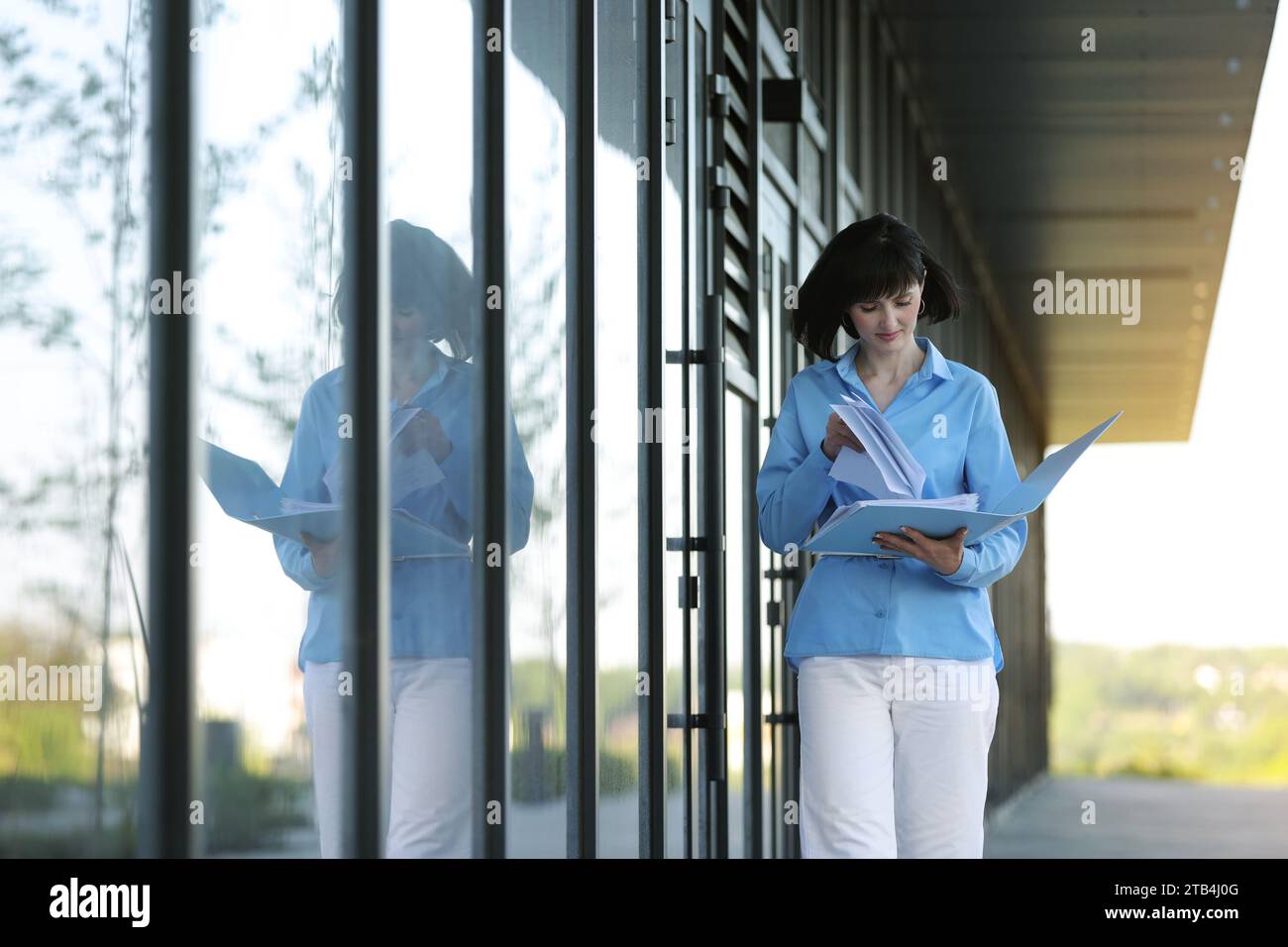Multitasking busy young business woman during walks reading and ...