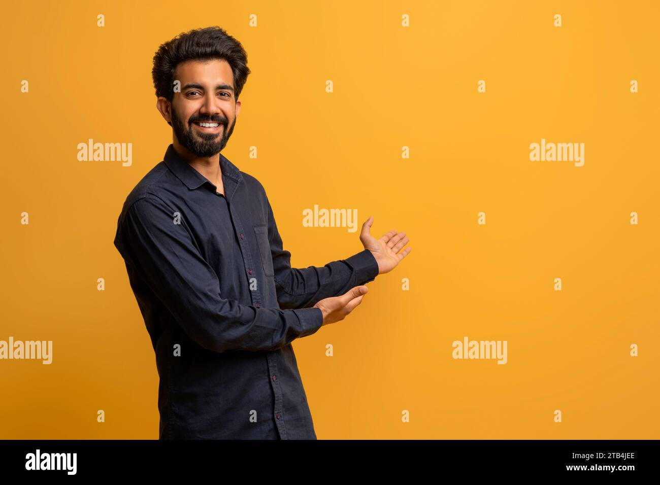 Handsome indian man making presenting gesture with his hand Stock Photo ...