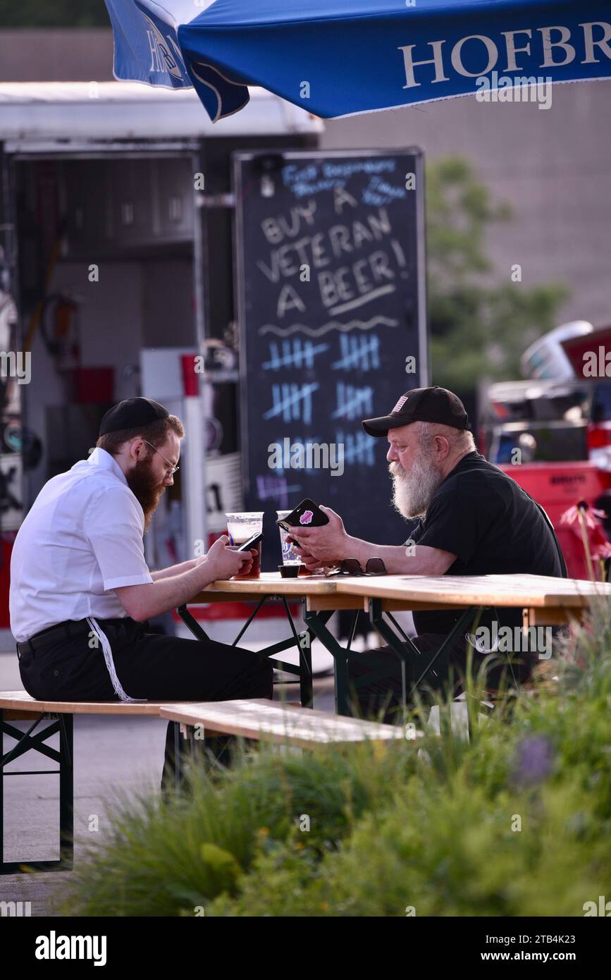 Two friends sharing companionship at a picnic table and beer garden ...