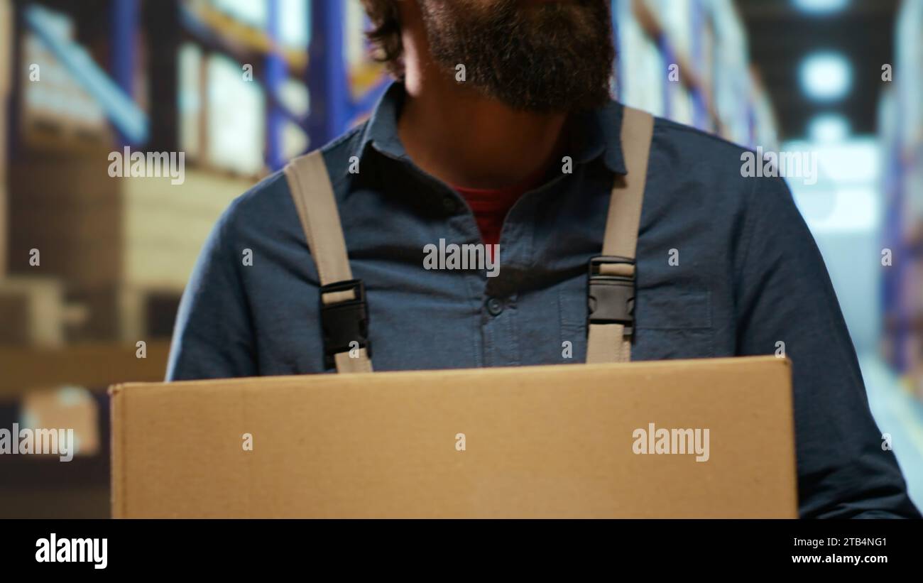 Packaging engineer carrying cargo boxes in depot, trying to organize ...