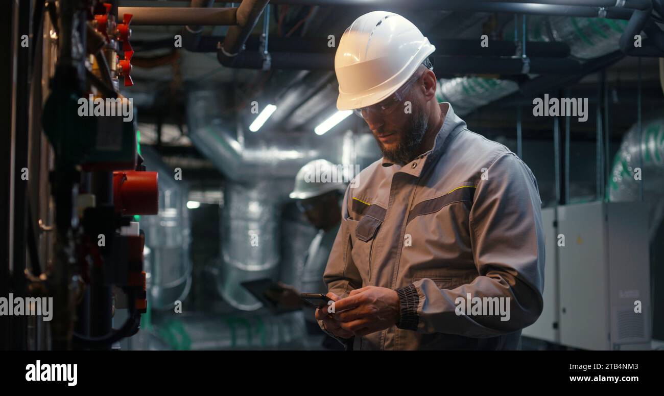 Technician worker wearing safety uniform and hard hat works on modern ...