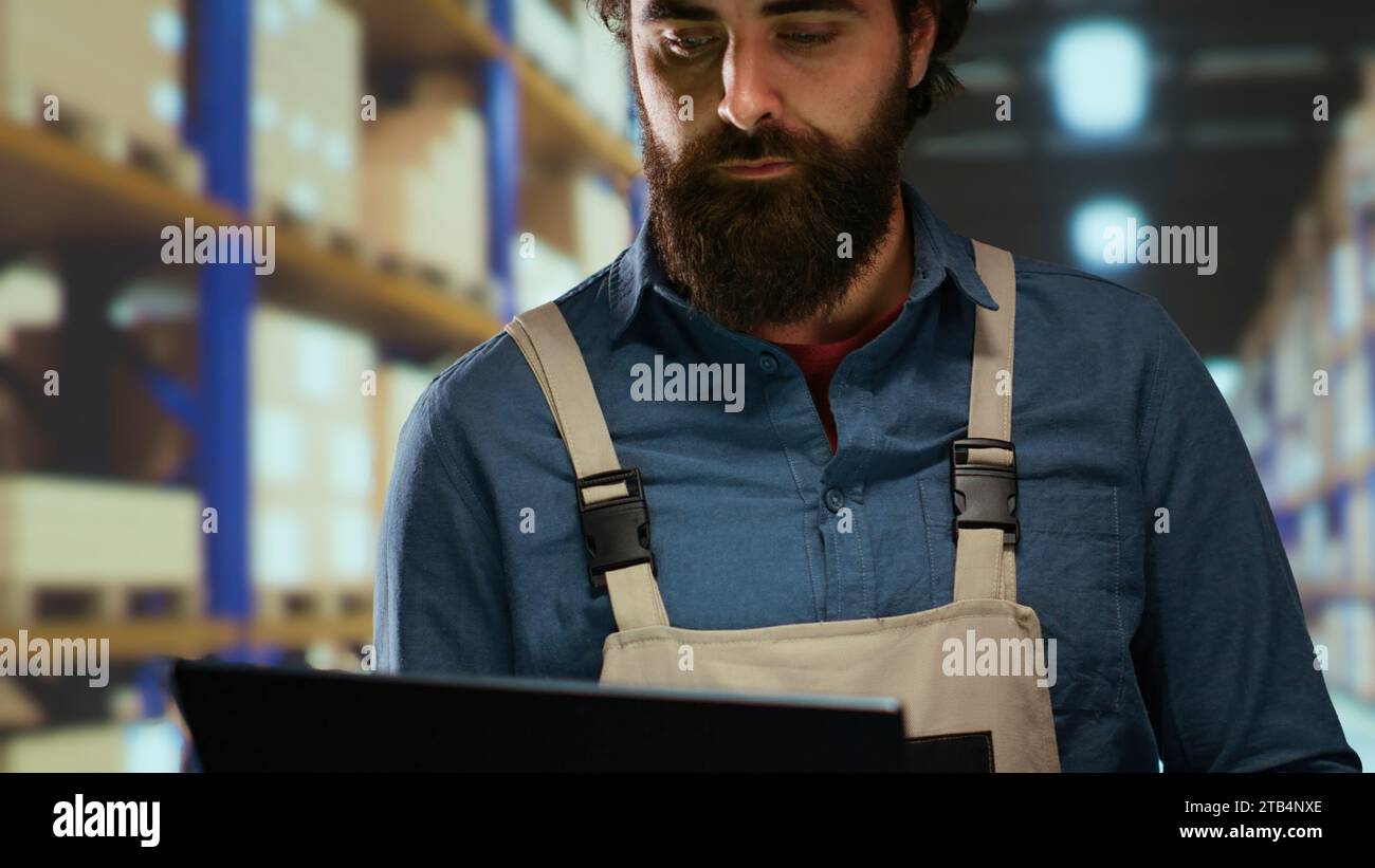 Factory engineer reviewing cargo packages in industrial depot, looking ...
