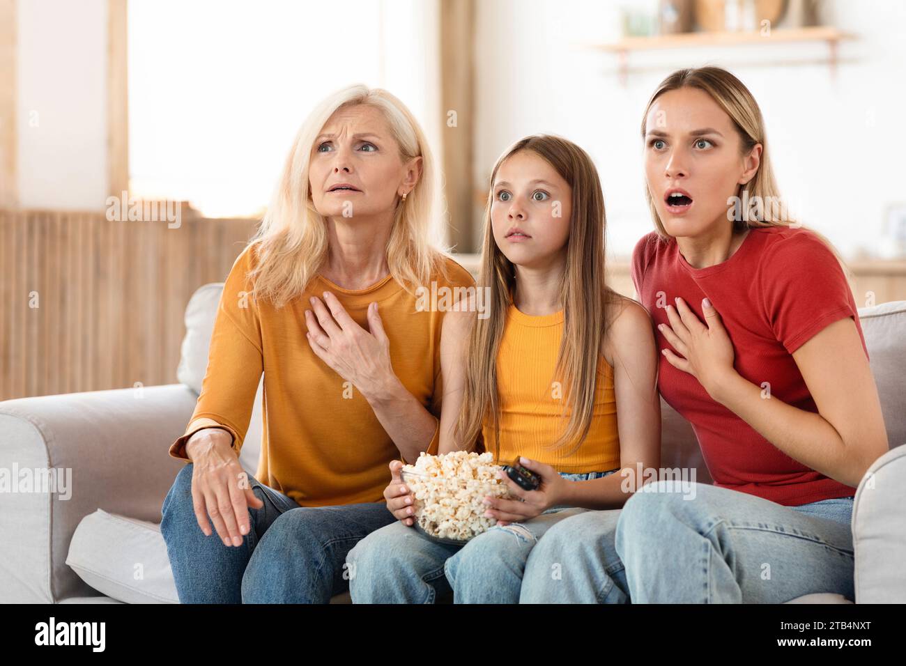Shocked family watching TV together at home Stock Photo - Alamy