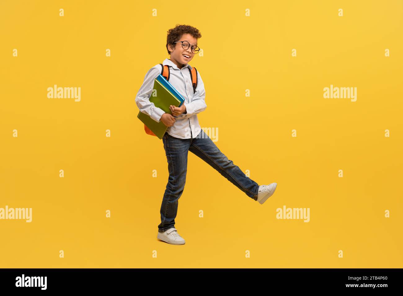 Happy student walking, books in hand Stock Photo - Alamy