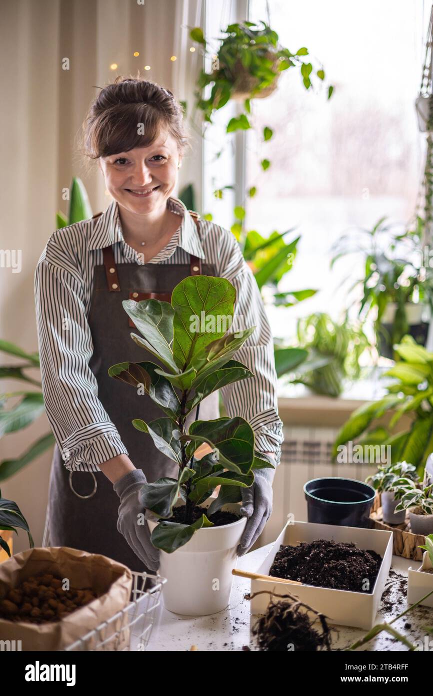 Smiling woman home garden transplant variegated monstera posing at ...