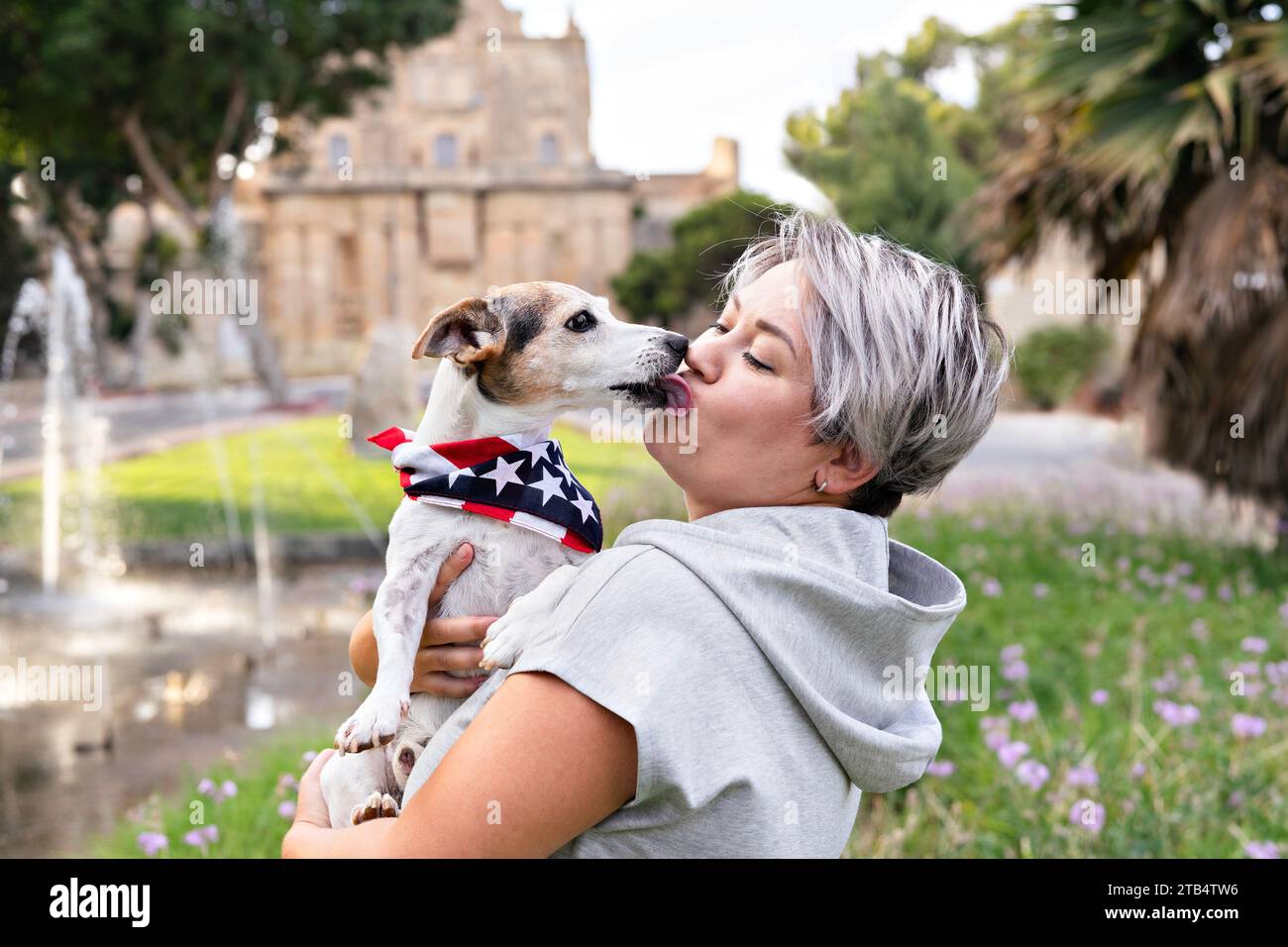 Woman with short grey hair holding and kissed on lips by small senior ...
