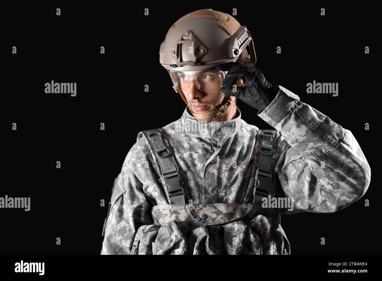 Young male soldier in helmet on black background Stock Photo - Alamy