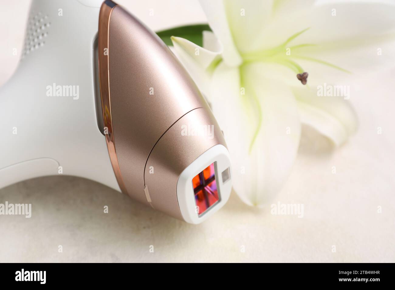 Modern photoepilator with lily flower on grunge white background Stock ...