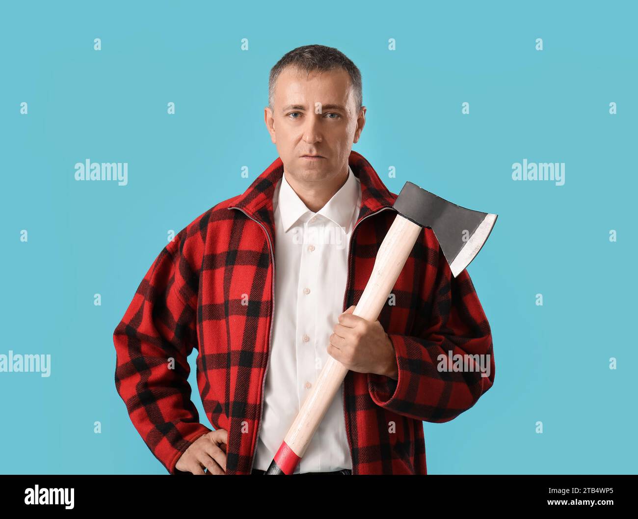Portrait of adult lumberjack with axe on blue background Stock Photo ...