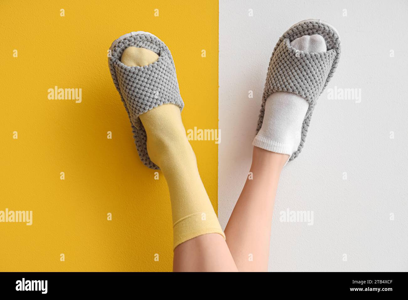 Female legs in soft slippers on yellow and white background Stock Photo ...