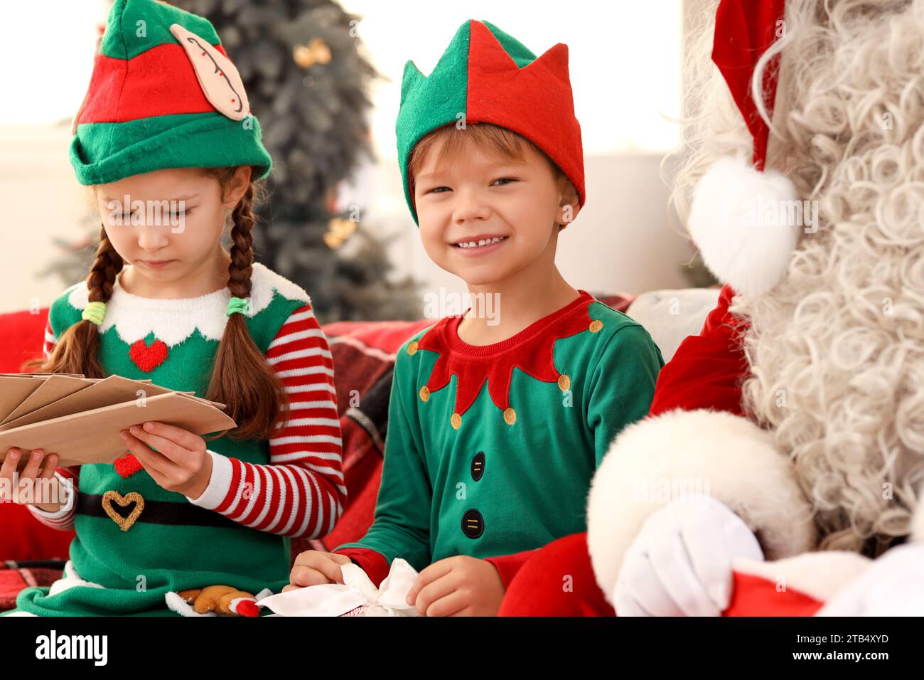 Little elves with Christmas gift and letters helping Santa Claus at ...