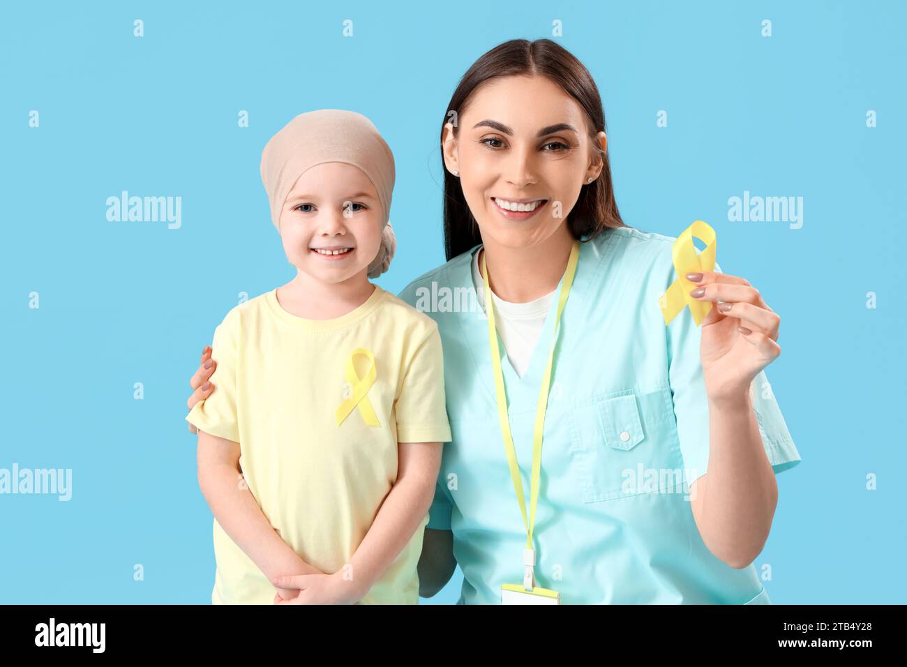 Little girl after chemotherapy and nurse with ribbons on blue ...