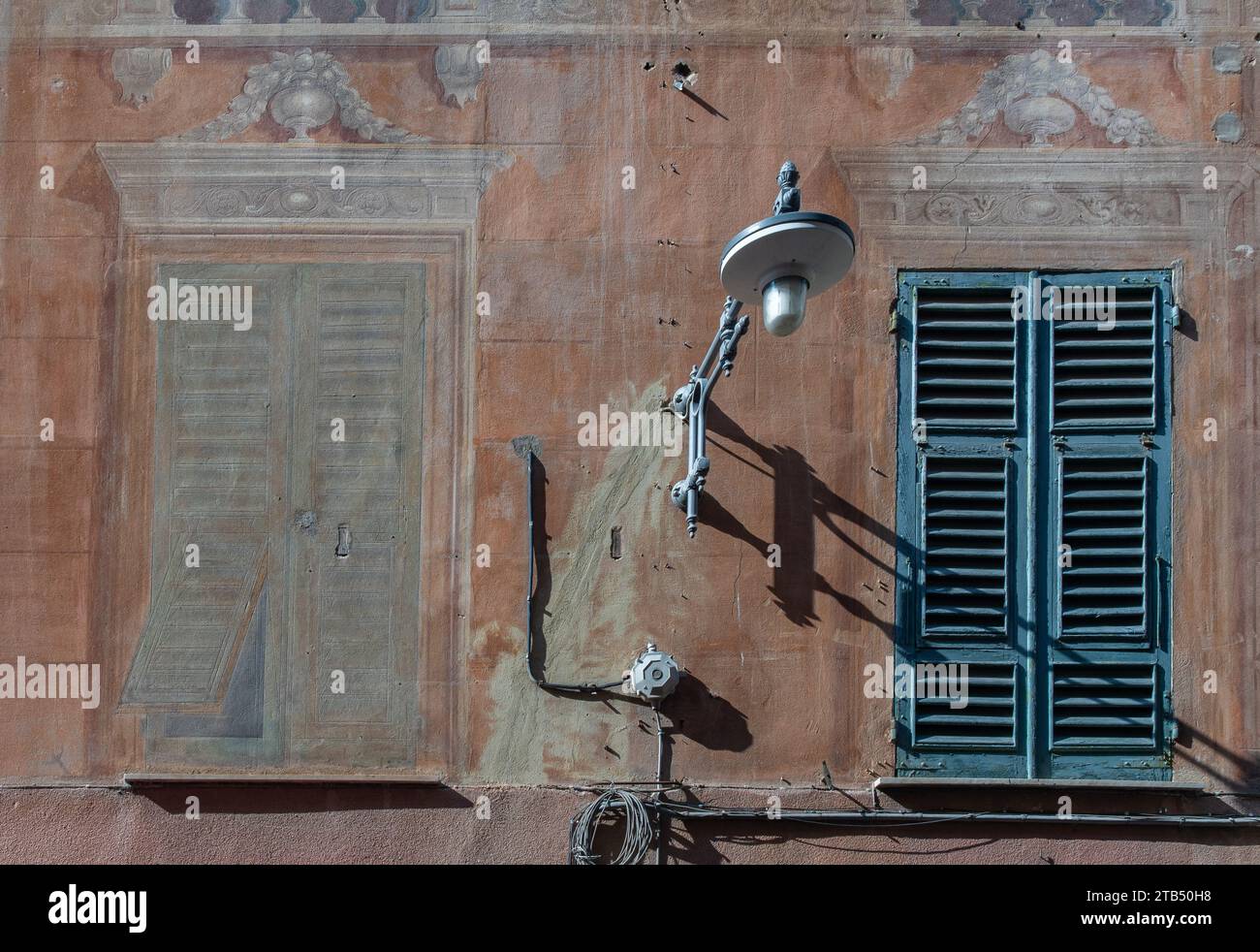 Detail of the exterior of an old house with a fake window, painted in ...