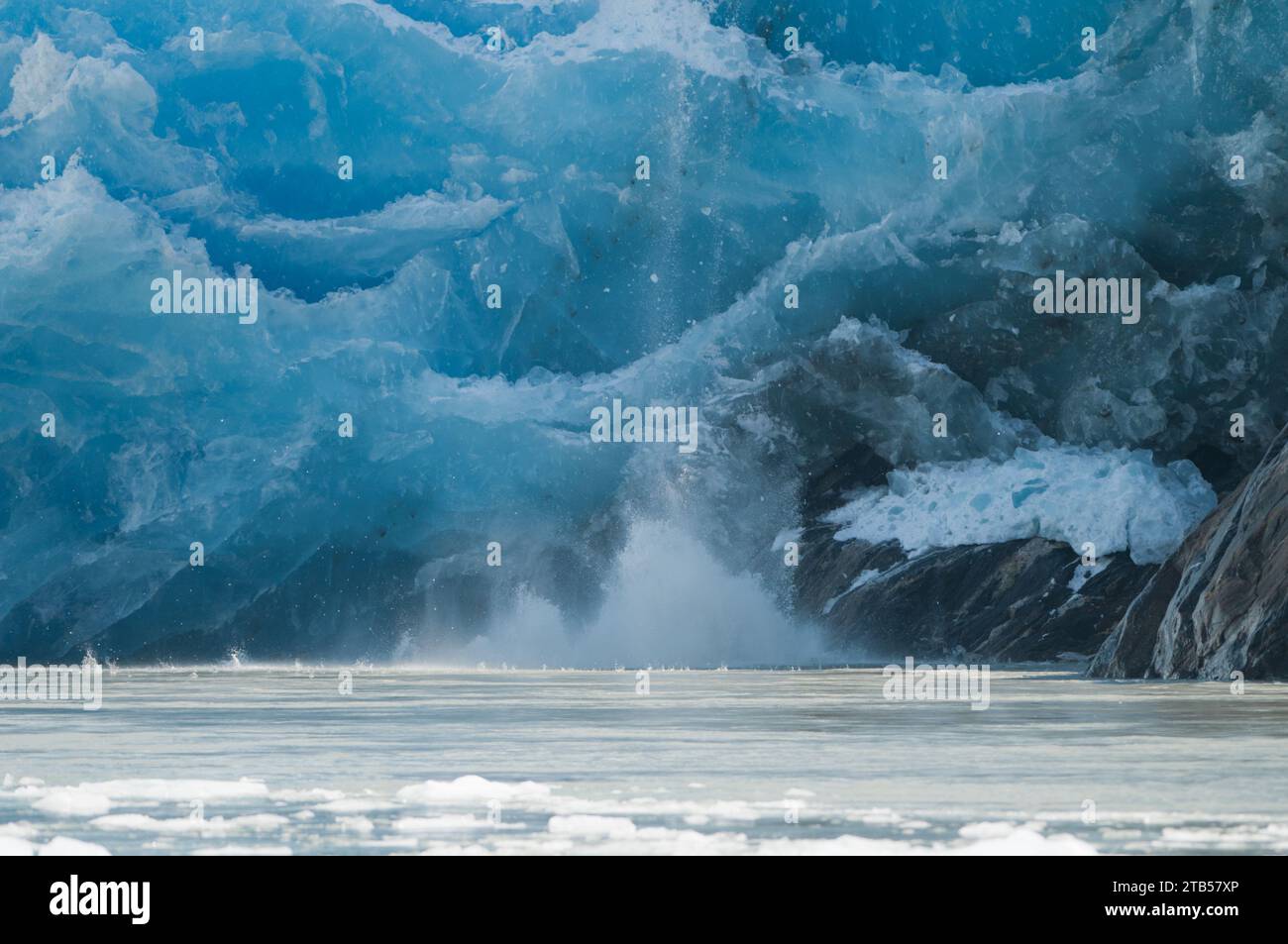 A glacier calves ice in to the ocean creating large splash Stock Photo - Alamy