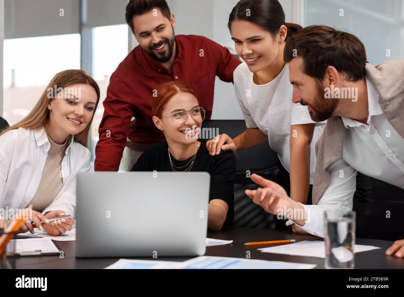 Team of employees working together in office Stock Photo - Alamy