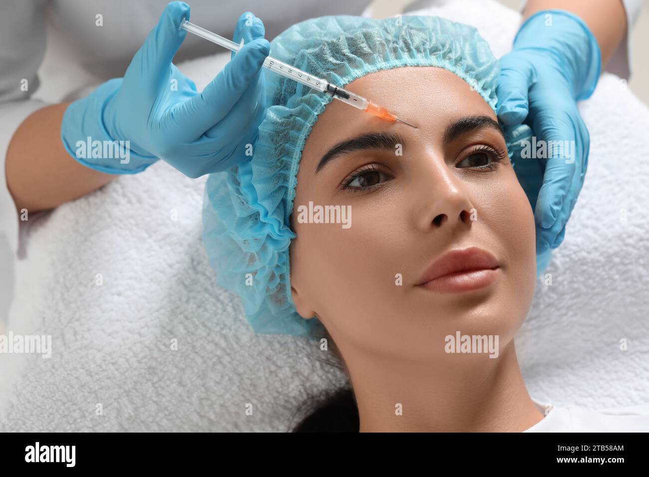 Doctor giving facial injection to young woman in clinic. Cosmetic ...
