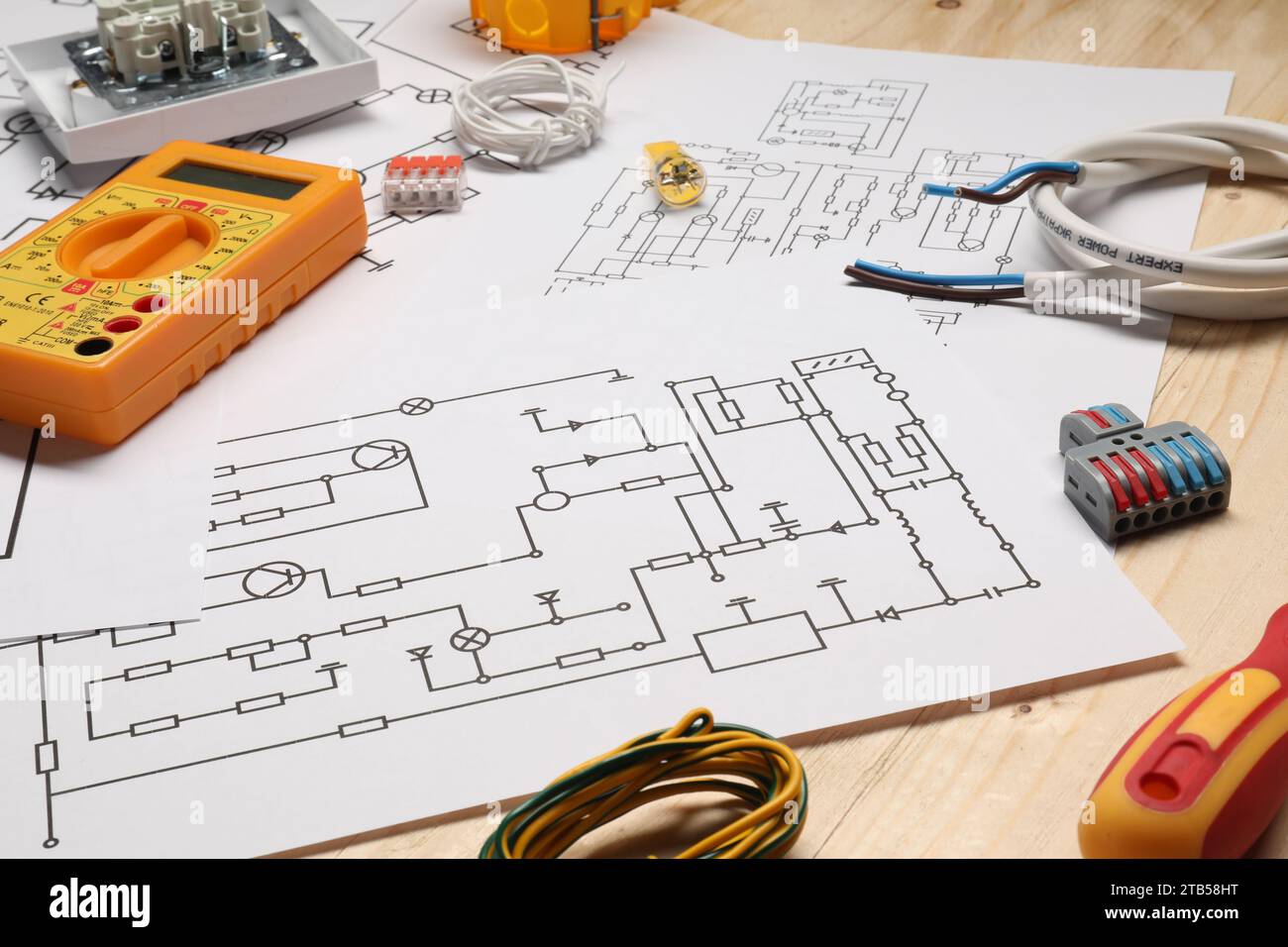 Wiring diagrams and different electrician's equipment on wooden table ...