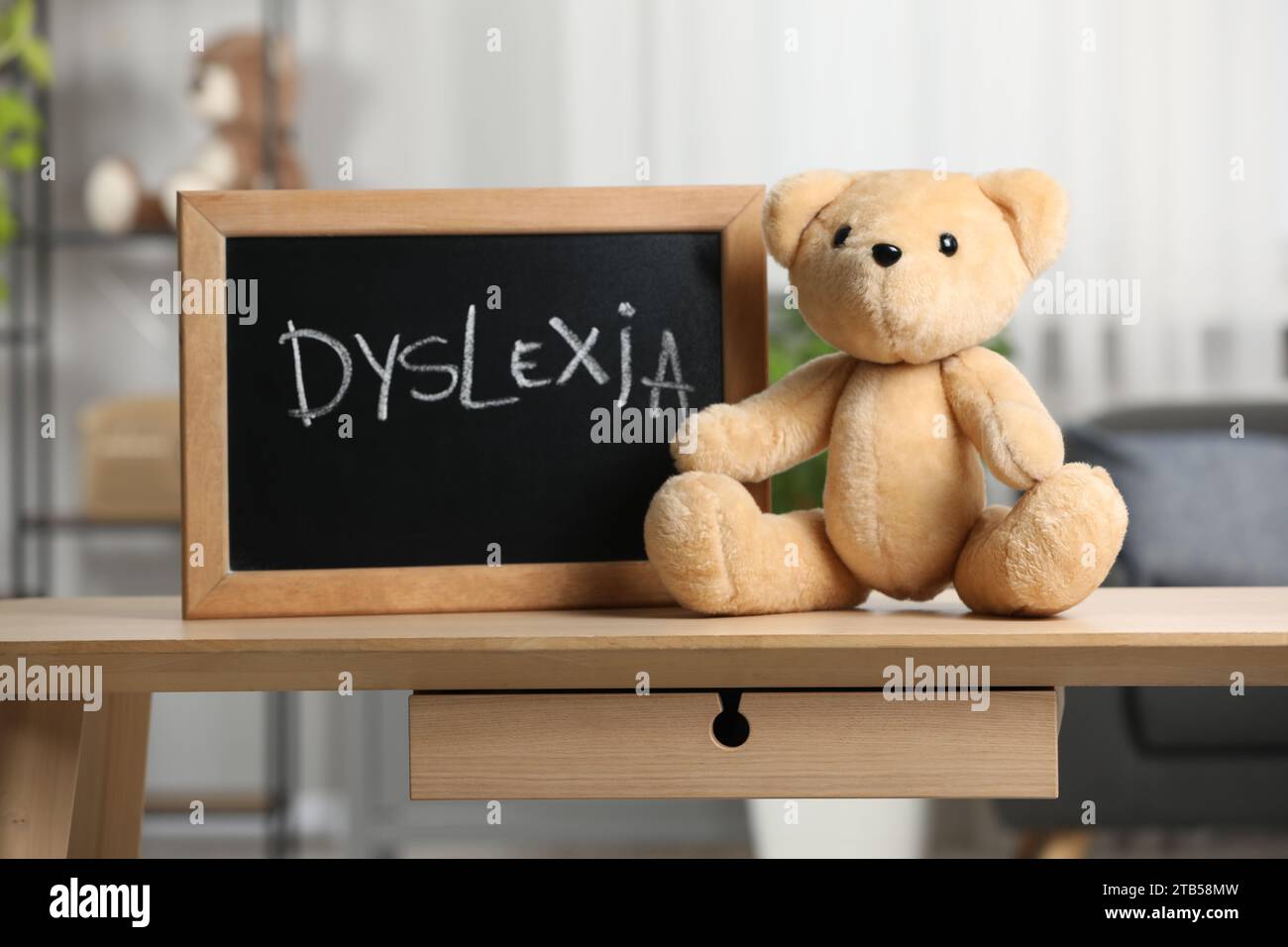 Teddy bear and small blackboard with word Dyslexia on wooden table in ...
