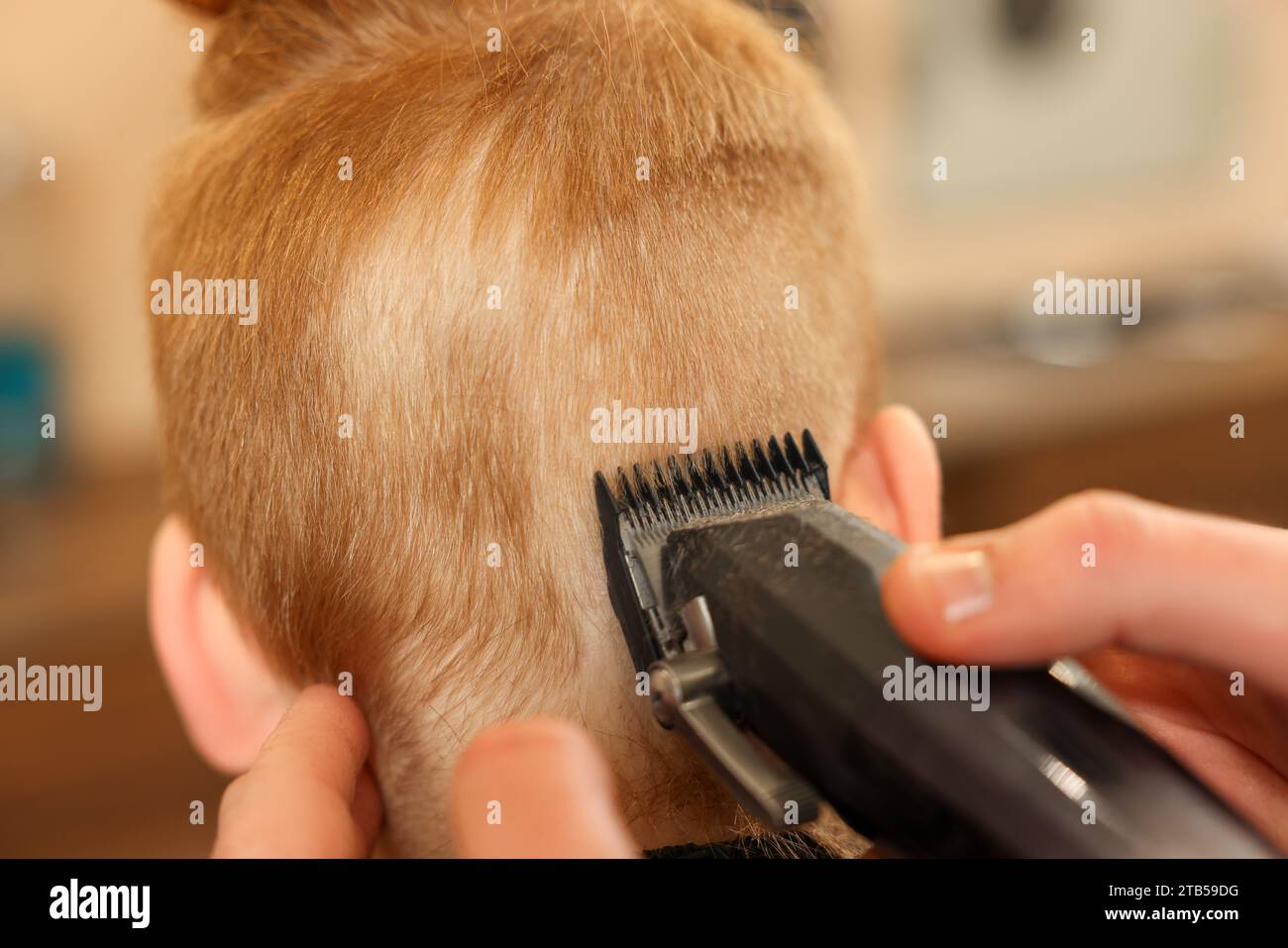 Professional hairdresser cutting boy's hair in beauty salon, closeup ...