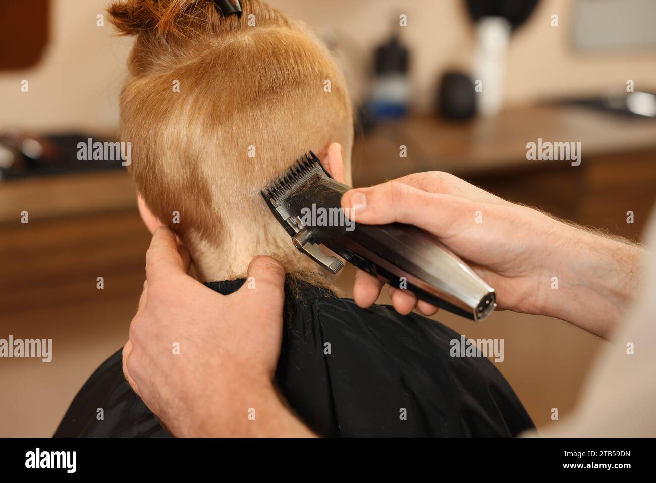 Professional hairdresser cutting boy's hair in beauty salon, closeup ...