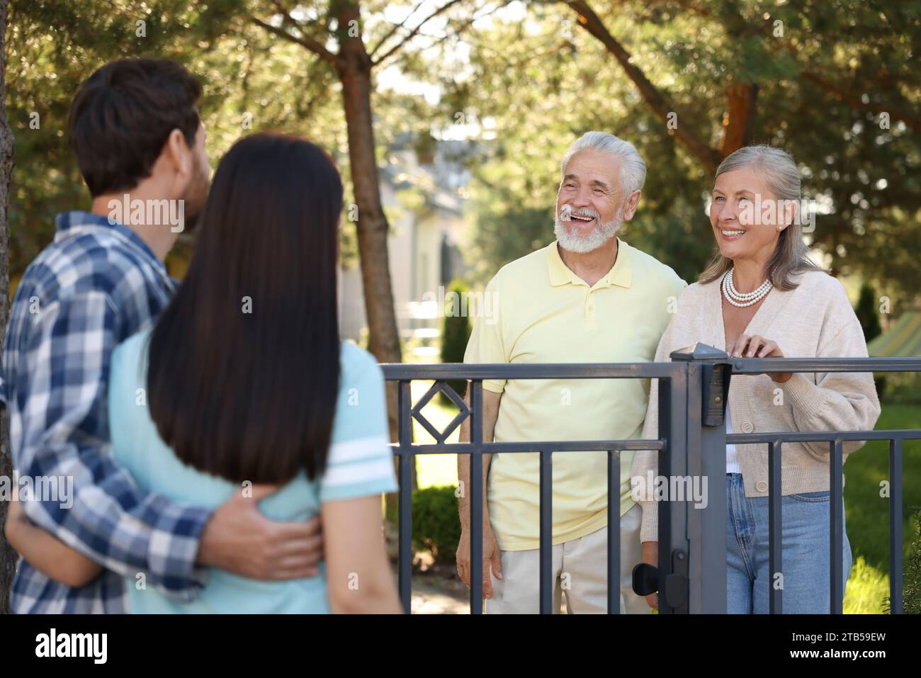 Friendly relationship with neighbours. Young family talking to elderly ...