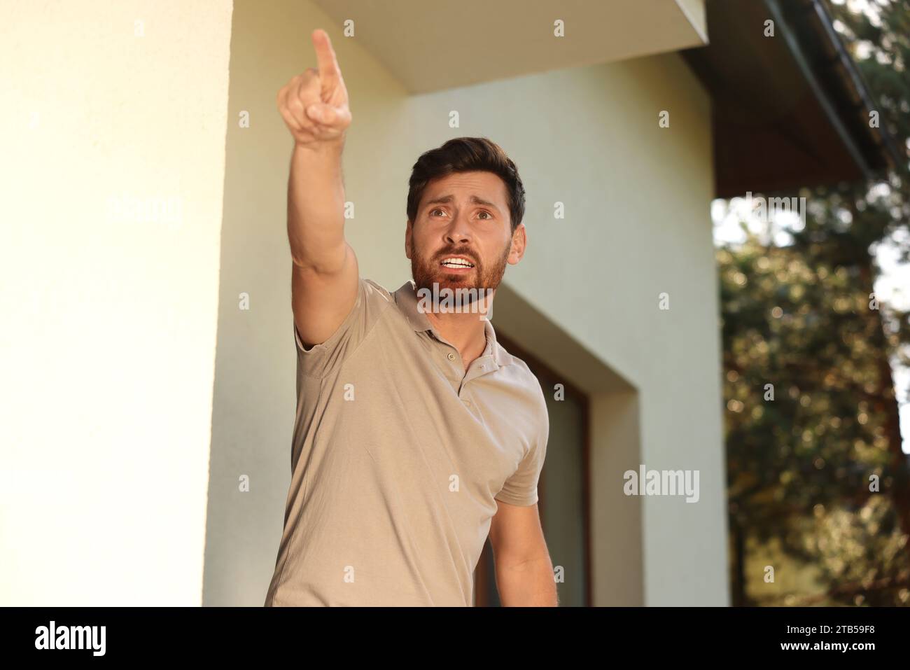Angry man pointing near house, low angle view. Annoying neighbour Stock ...