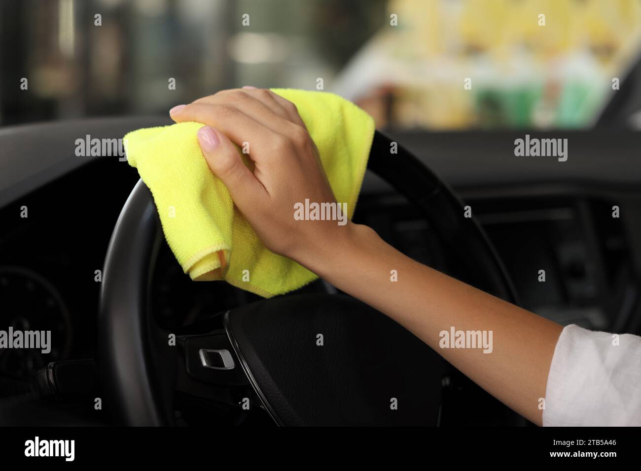 Woman cleaning steering wheel with rag in car, closeup Stock Photo - Alamy
