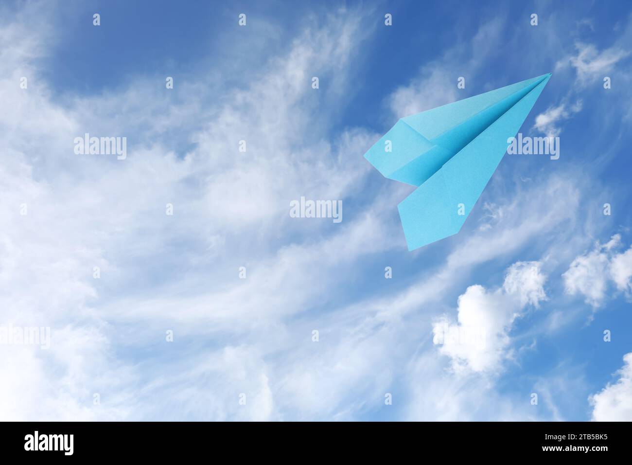 Light blue paper plane flying in sky with clouds with clouds Stock ...