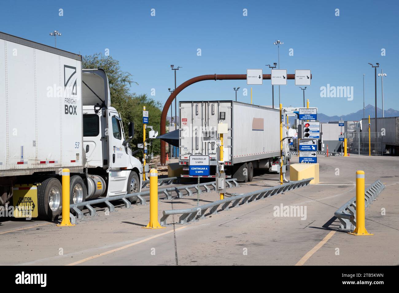 Arriving commercial vehicles wait in line to pass through the Multi ...