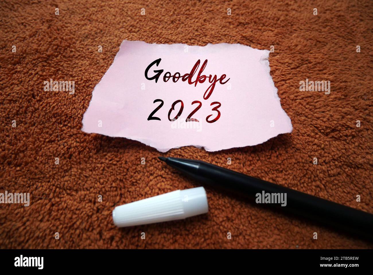 hand holding paper with the words BYE, BYE 2023 on a piece of note ...