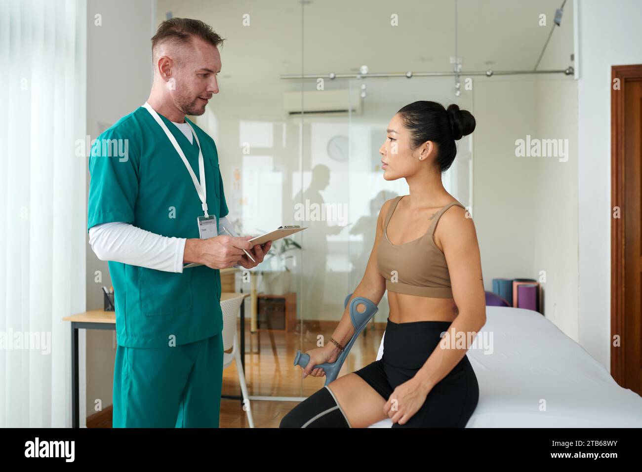 Sports medicine physician explaining prescription to young woman ...