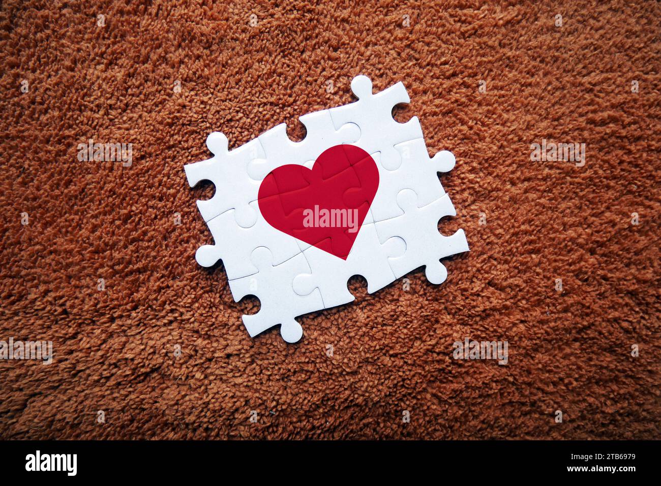 Puzzle pieces that make up a heart on the yellow background. The ...