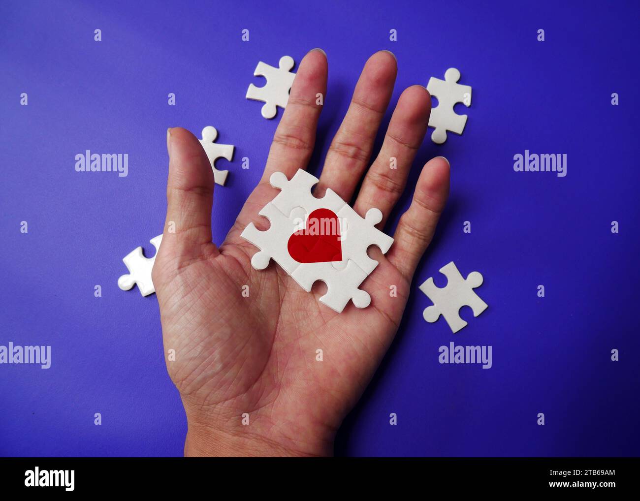 A hand with puzzle pieces that make up a heart. The concept of a ...
