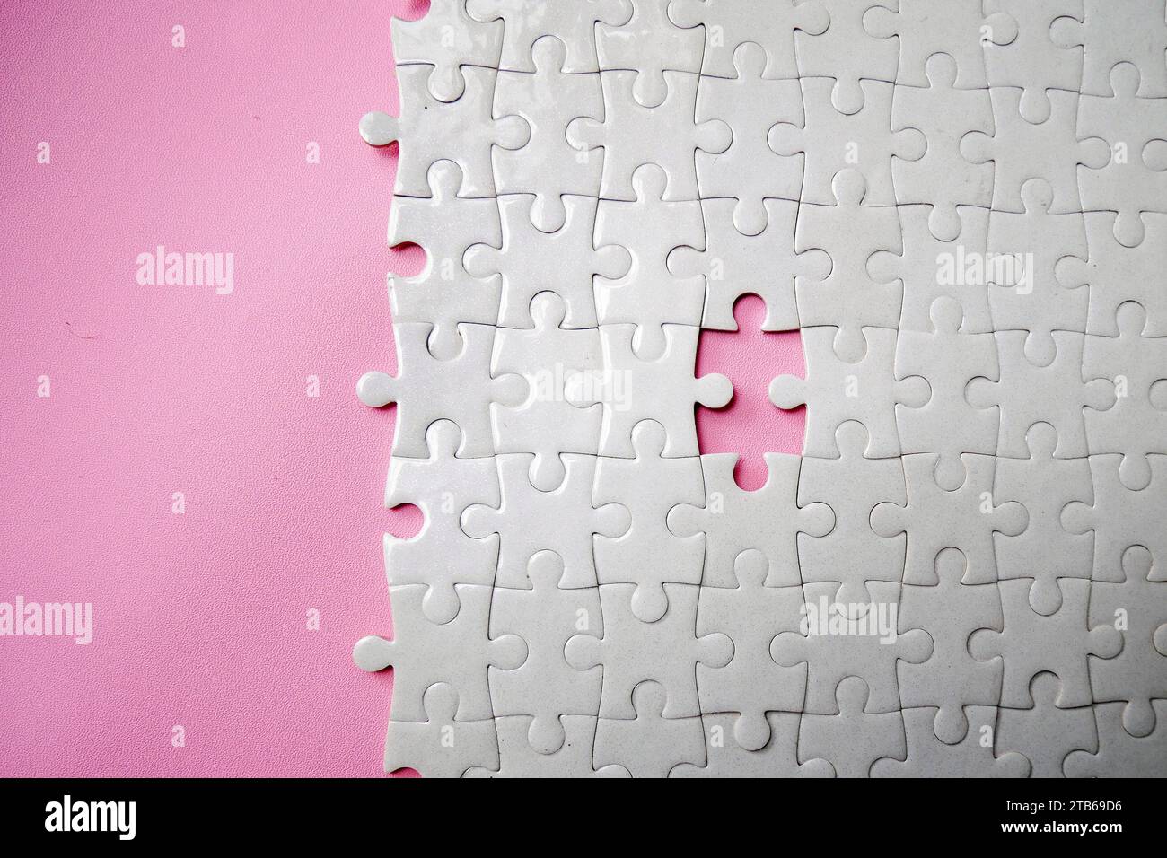 White jigsaw puzzle pattern missing pieces on pink background. Concept ...