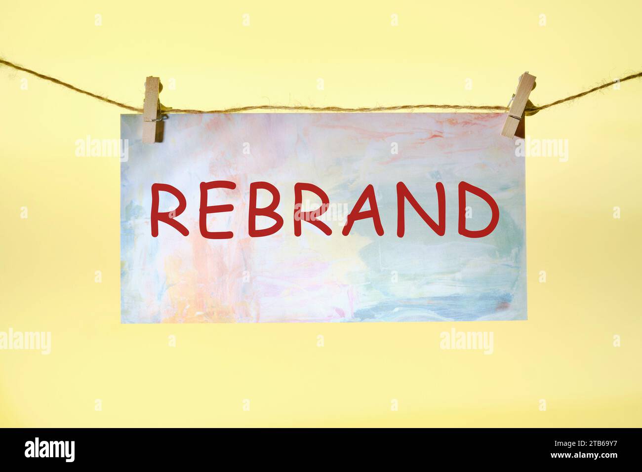Rebrand lettering on colored paper hanging in front of a yellow ...