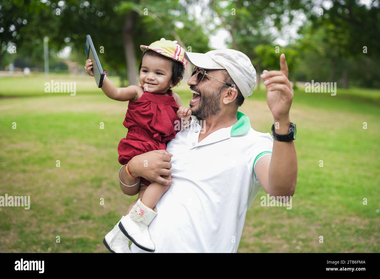 Beautiful Young indian father wearing hat and sunglasses dancing with ...