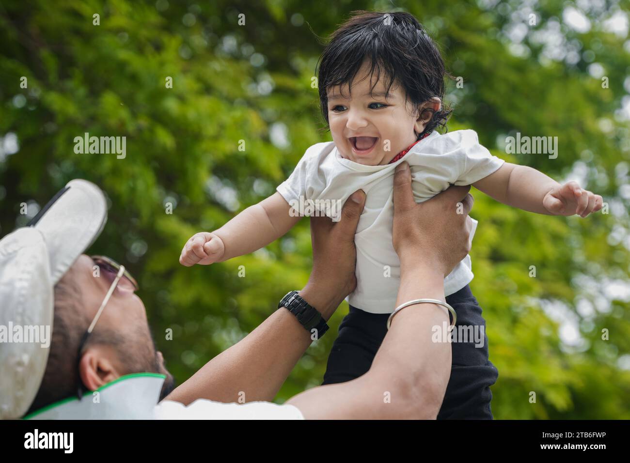 Beautiful Young indian father throwing baby boy up in air and catching ...