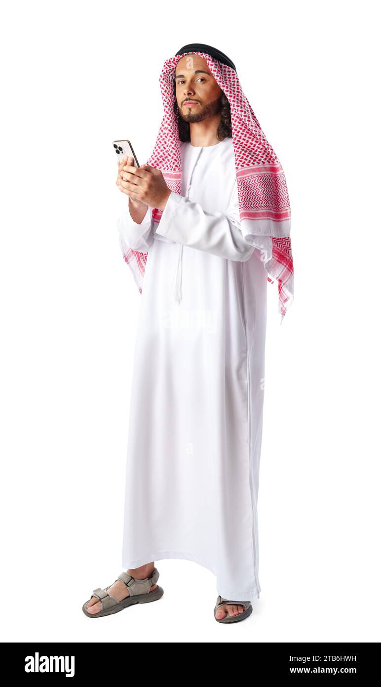 Young Arab man in traditional dress thobe using smartphone at white ...