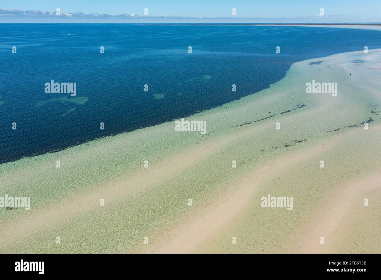 Aerial view of pools of water on a white sandy beach formed in long ...