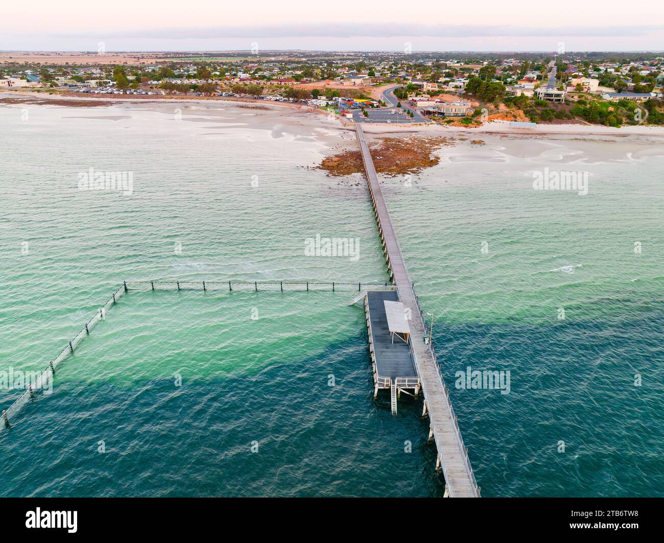 Aerial view of a long narrow jetty running over rocks and beach to ...
