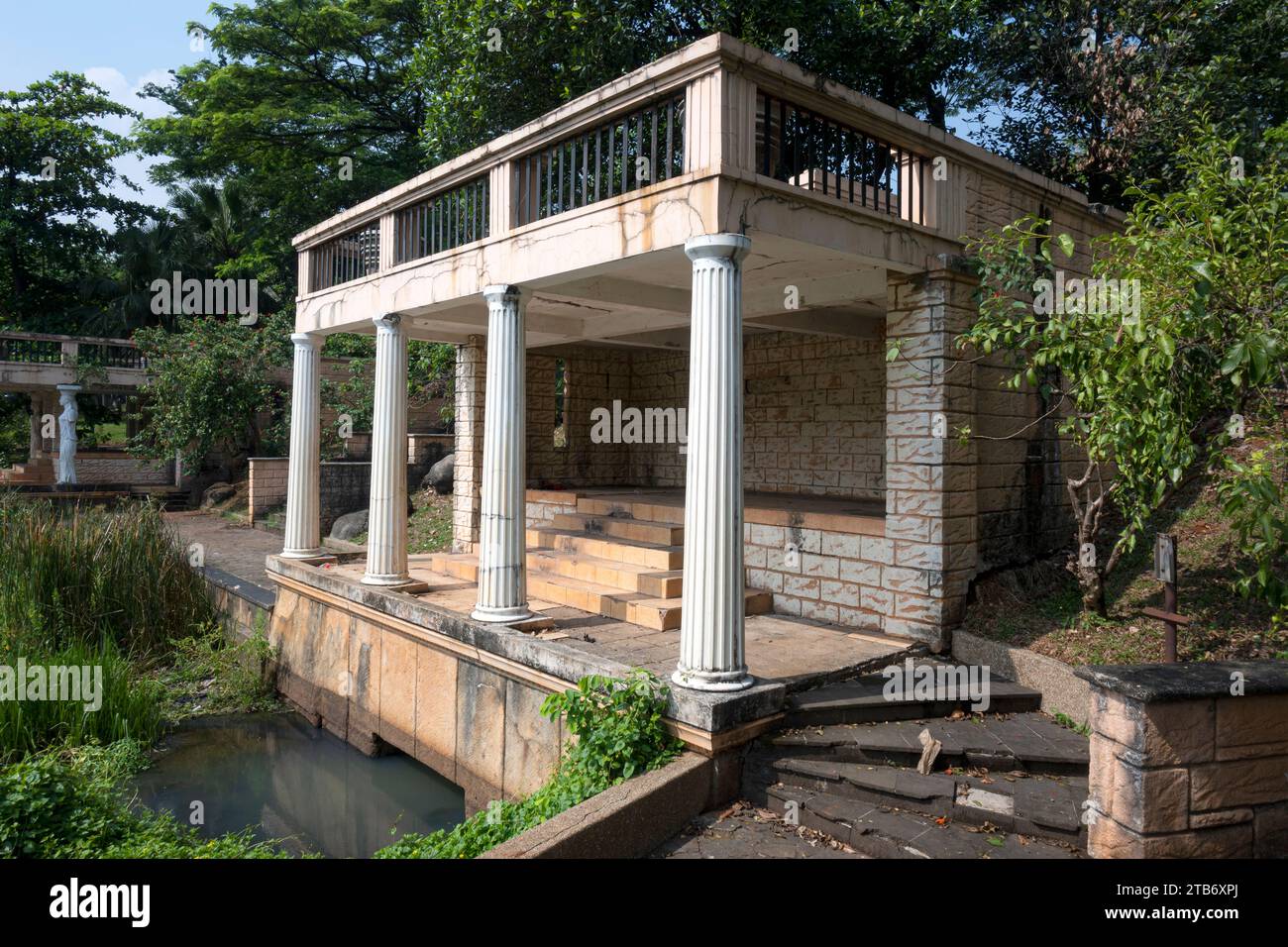 Building with stone pillars and a terrace above with a blue sky ...