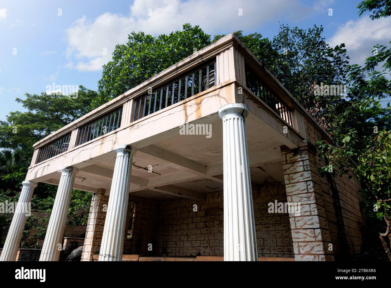 Building with stone pillars and a terrace above with a blue sky ...