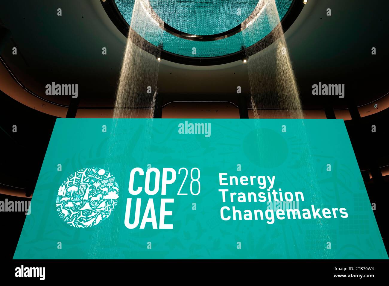 Water flows near a sign for Energy Transition Changemakers at the COP28 ...