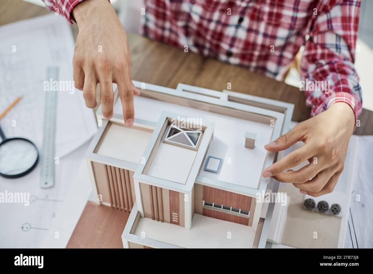 Male architect holding and working on model of architectural house top ...