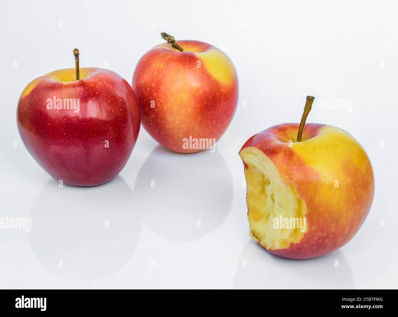 A bitten ripe apple and two whole Gala apples isolated on a white ...