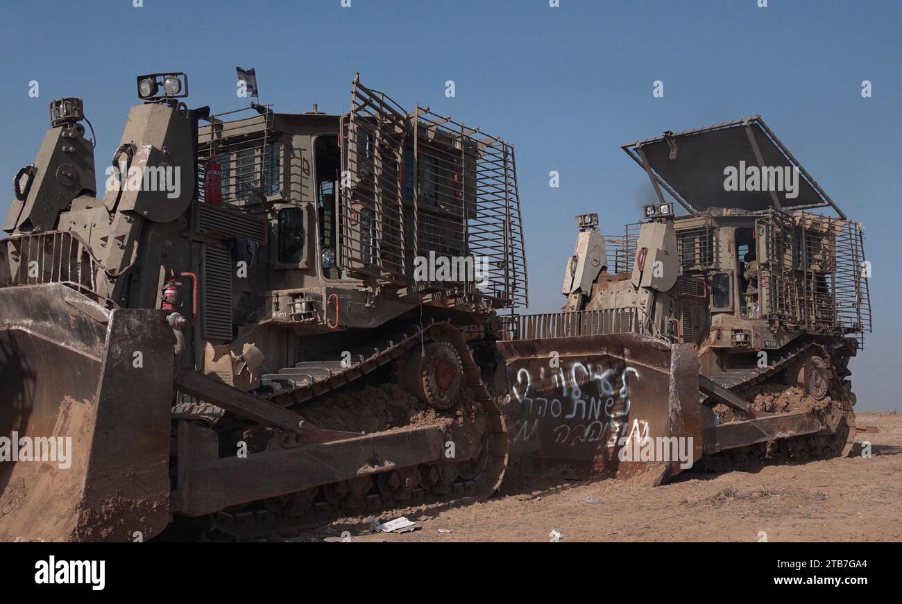 Israeli D9 armored military bulldozers stand in a field near the border ...