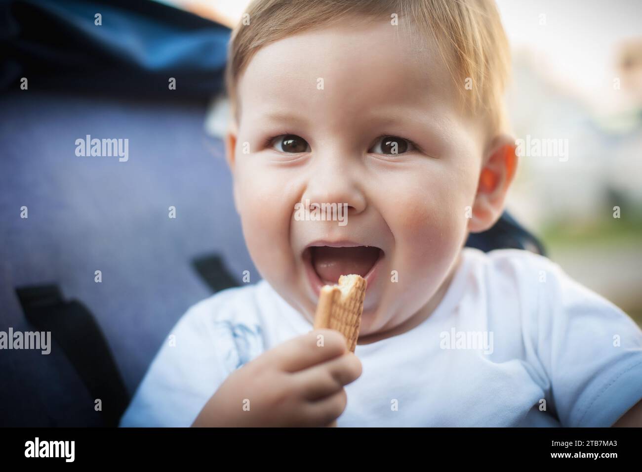 Portrait of happy and smilling cute baby boy eating his favorite child ...