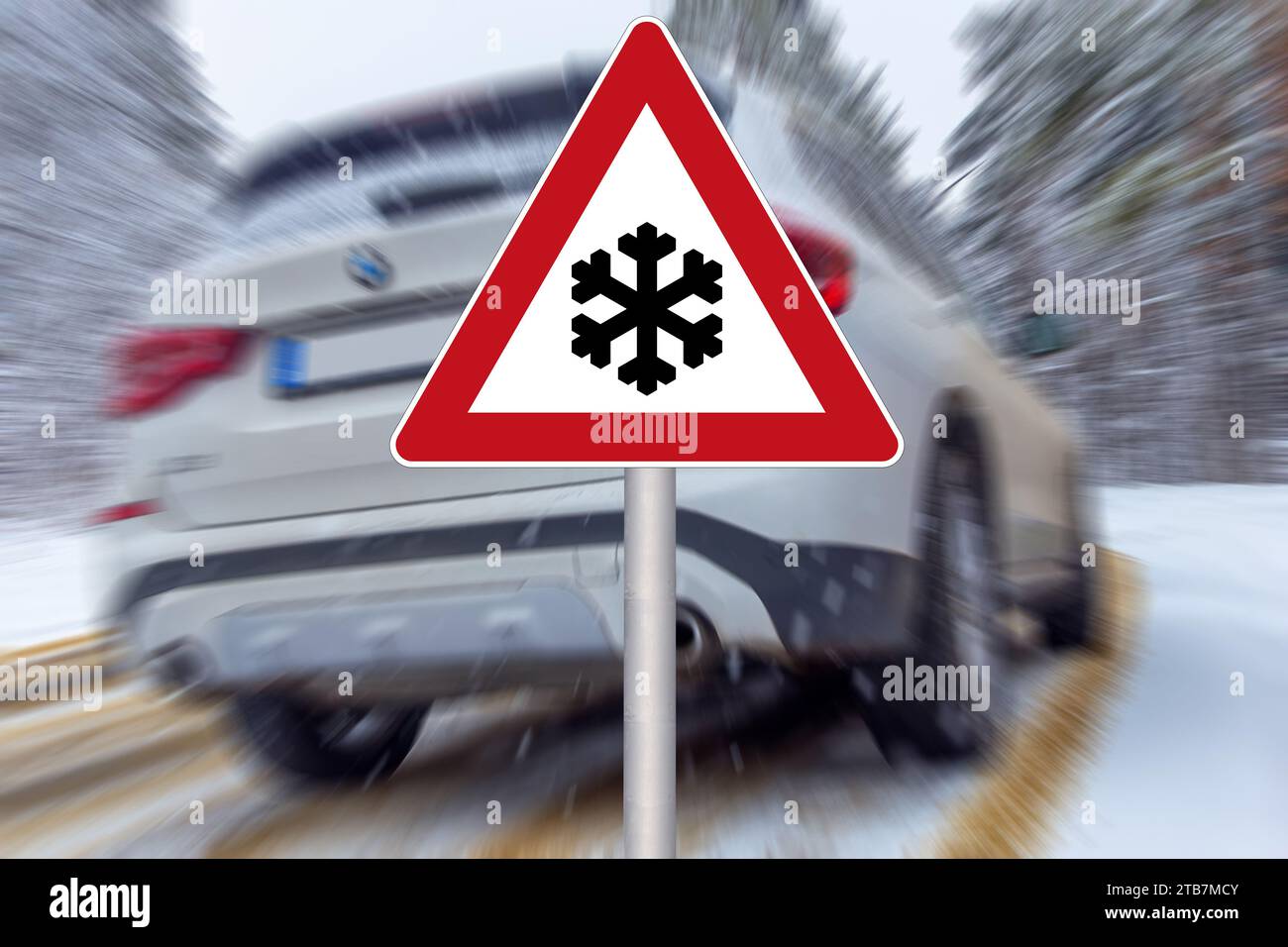Slippery snow or icy road sign in front of a car in winter road ...