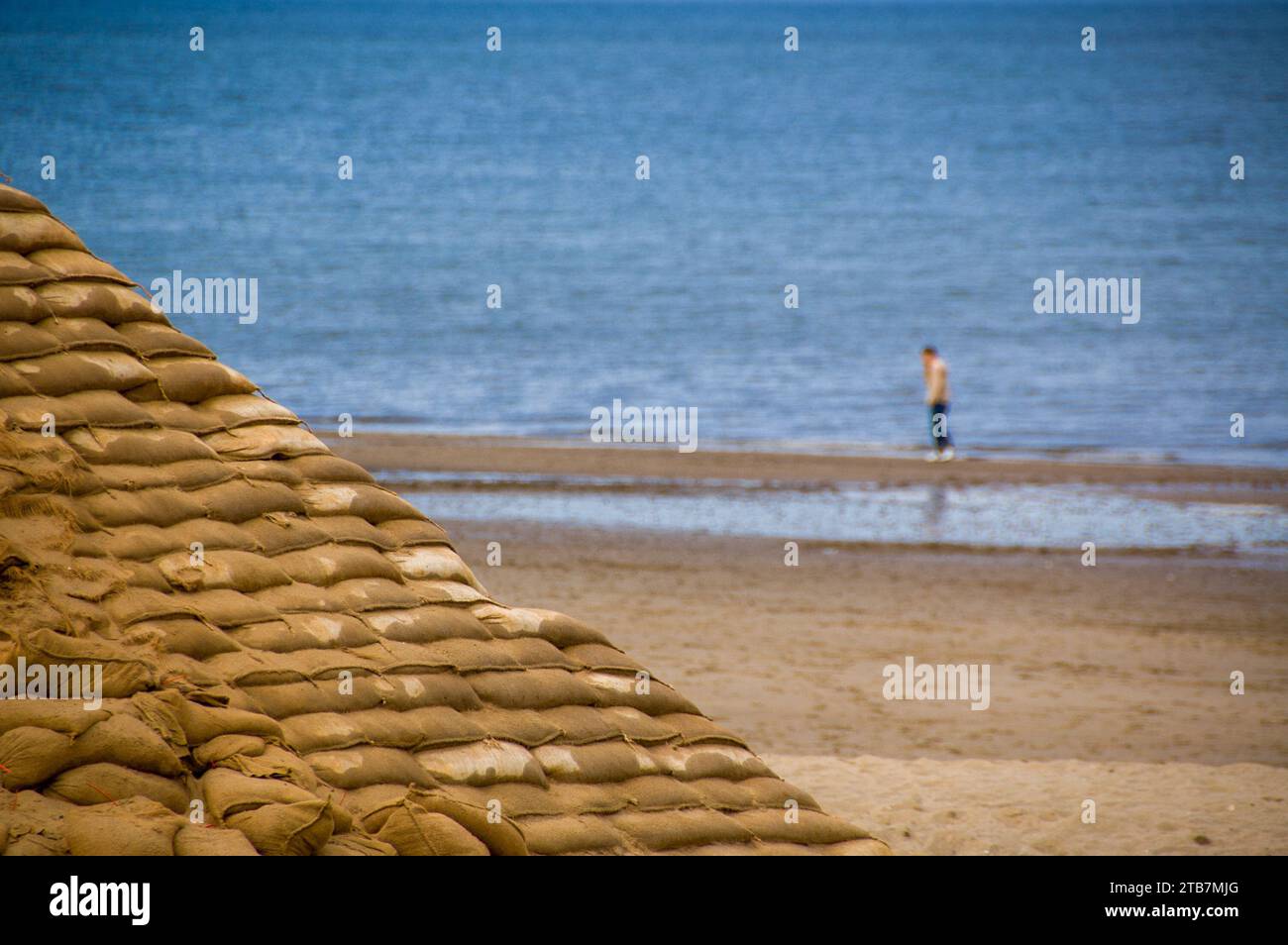 Art installation of sandbag pyramids on the beach Stock Photo - Alamy
